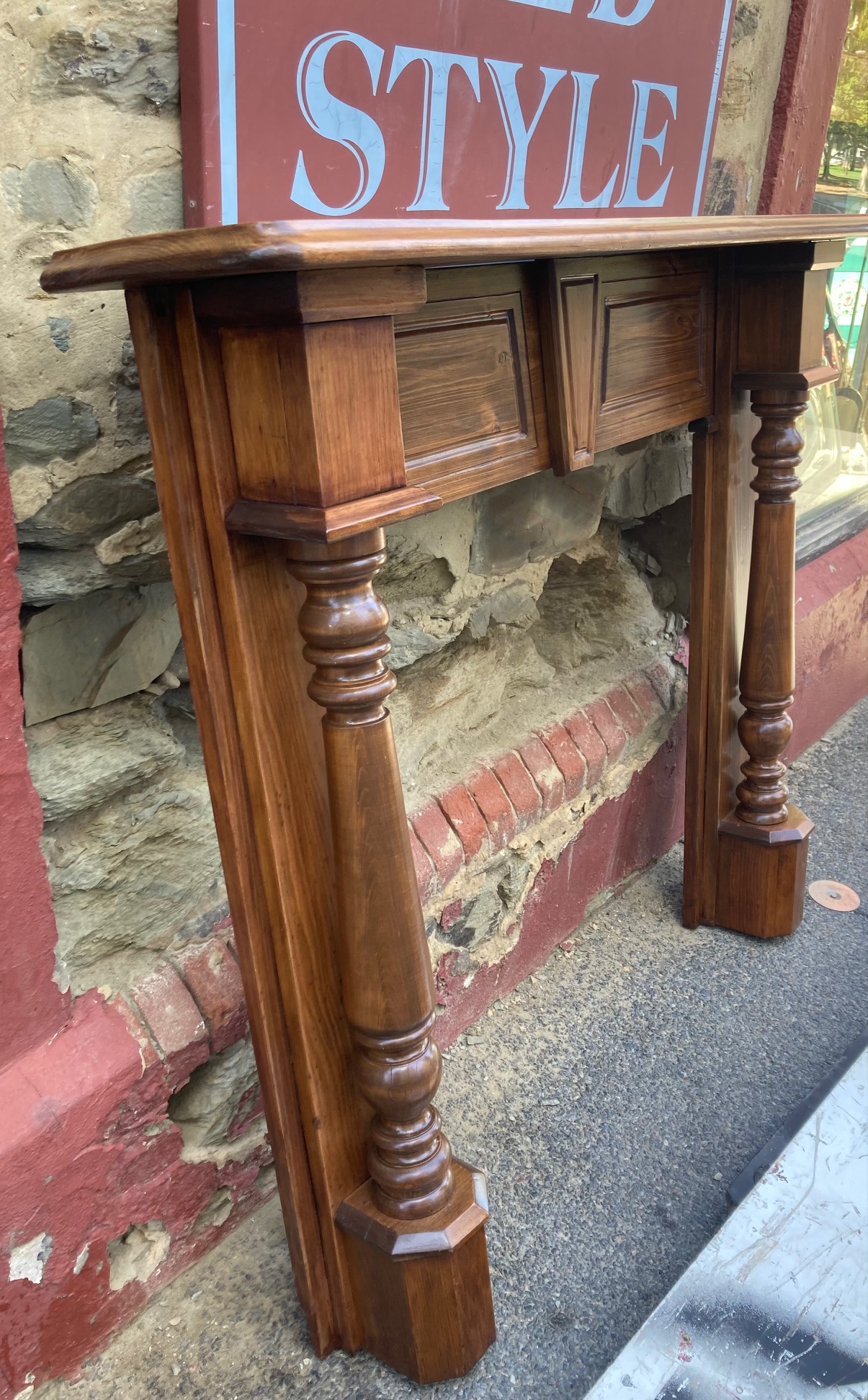 Detail of polished timber mantelpiece with pillared legs, top shelf ...